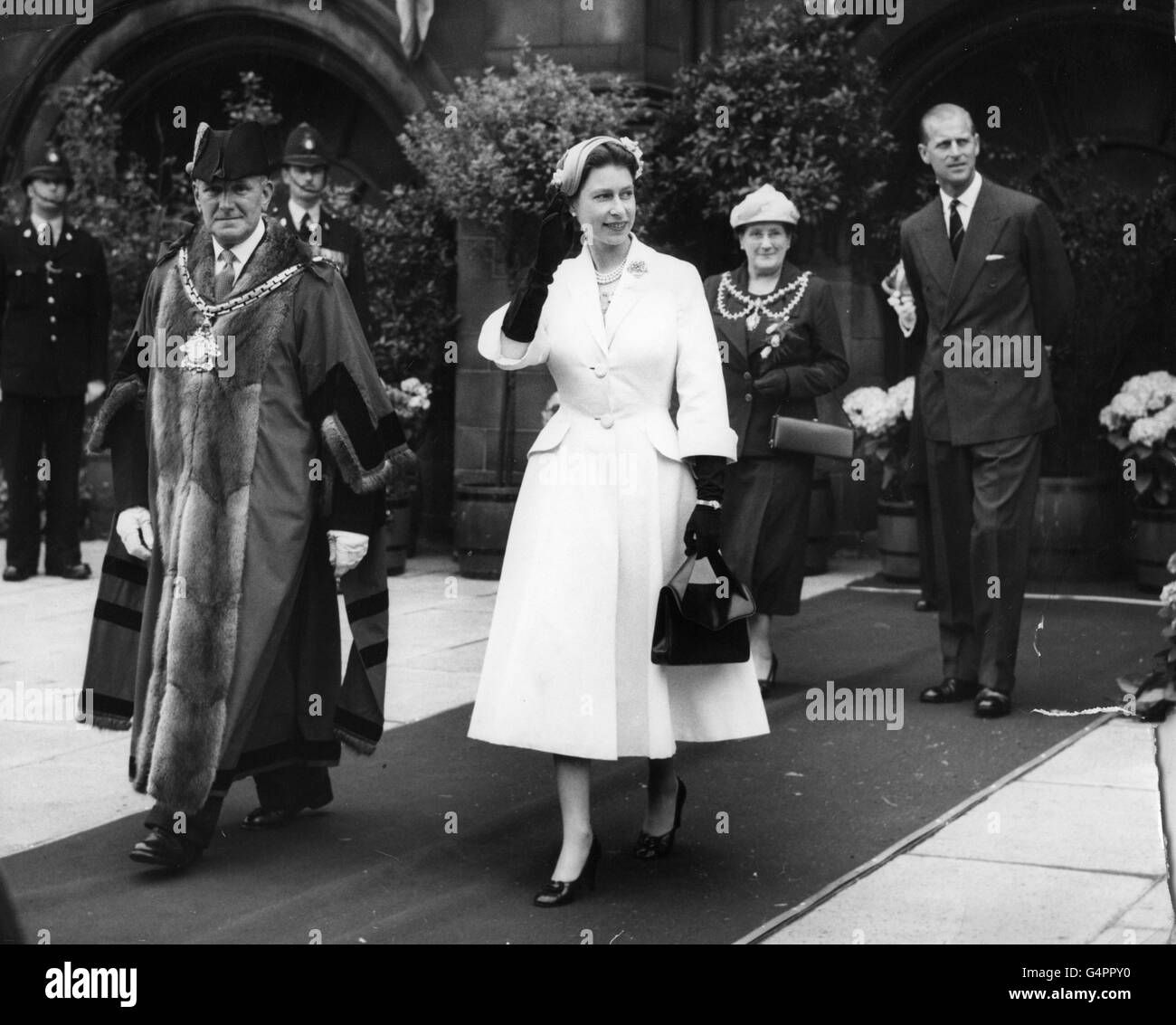 Queen Elizabeth II turns to smile and wave to the crowd as she leaves ...