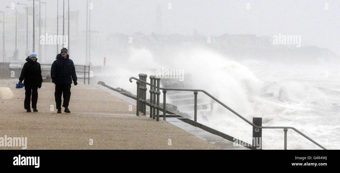 Couple walk along wet windy promenade in blackpool hi-res stock ...
