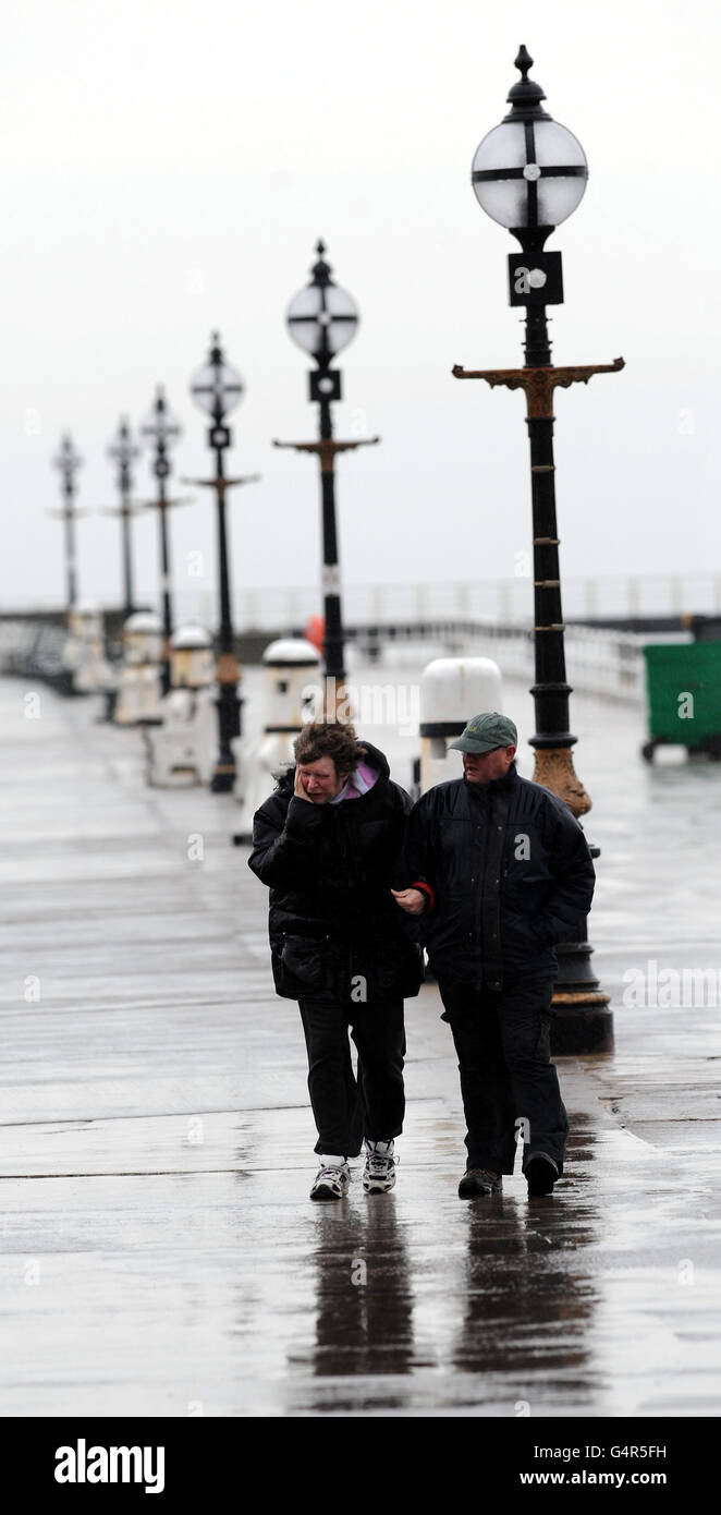 Two people (names not known) brave the elements on the promenade at Whitby Stock Photo - Alamy