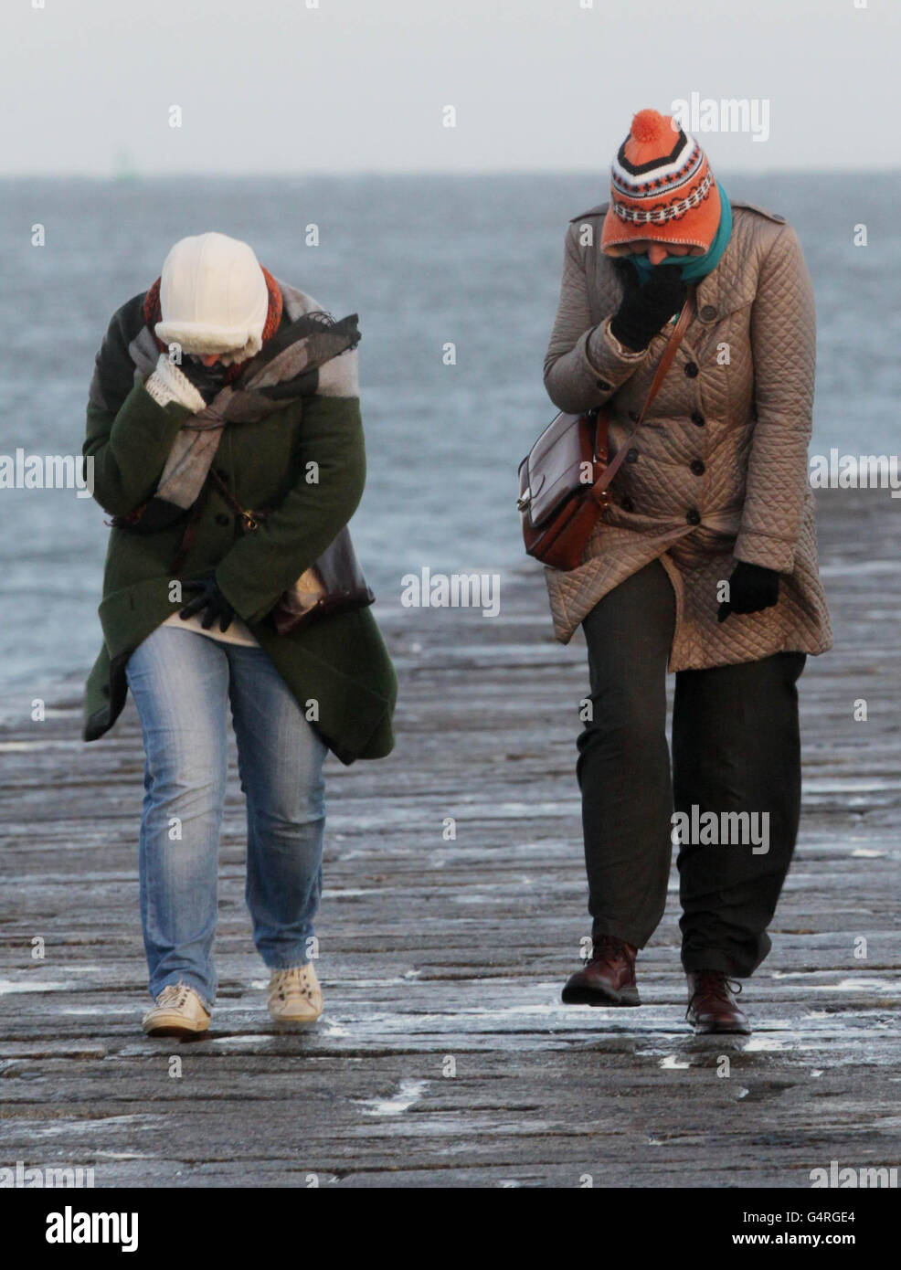 Two women walk along the Great South Wall in Dublin as high winds swept ...