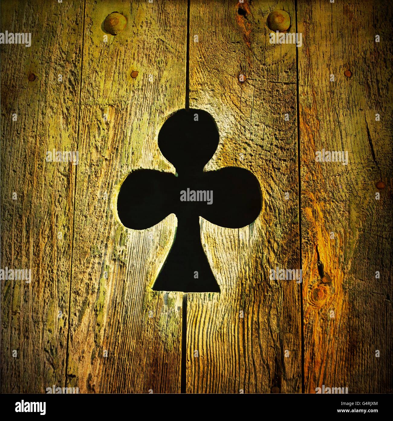 Clover shape cut out of wooden door Stock Photo - Alamy