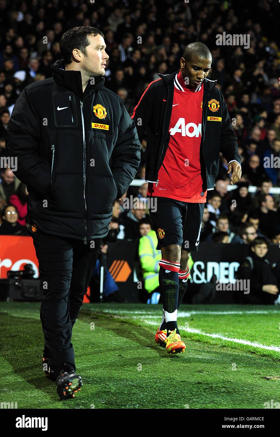 Manchester United's Ashley Young (right) hobbles around the edge of the ...