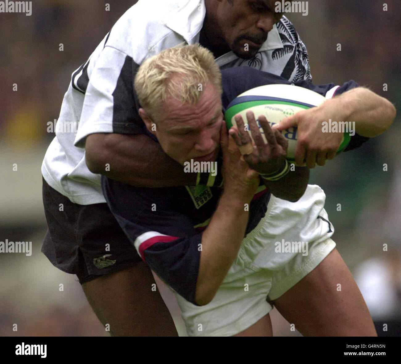 Neil Back of England evades the tackle of Marika Vunibaka of Fiji to ...