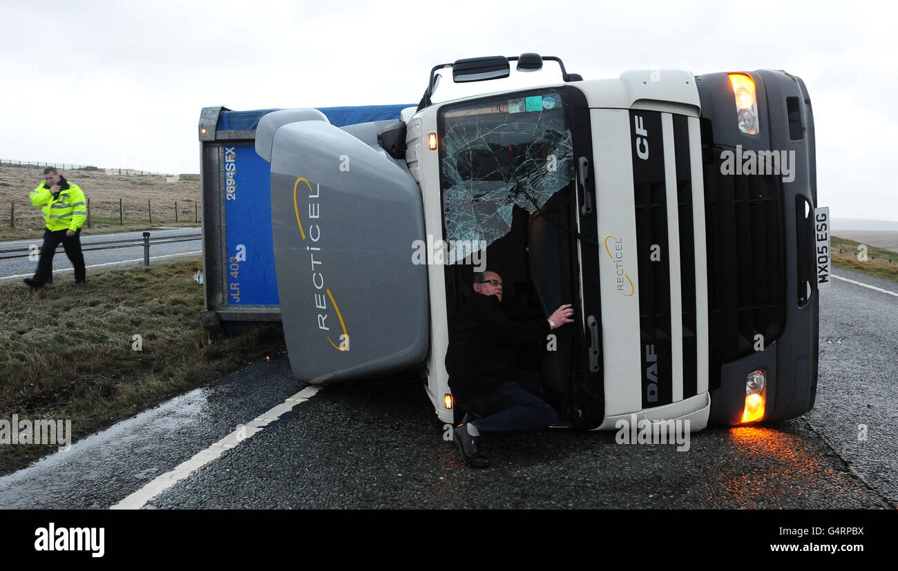 A lorry lies on its side after being blown over in high winds on the ...