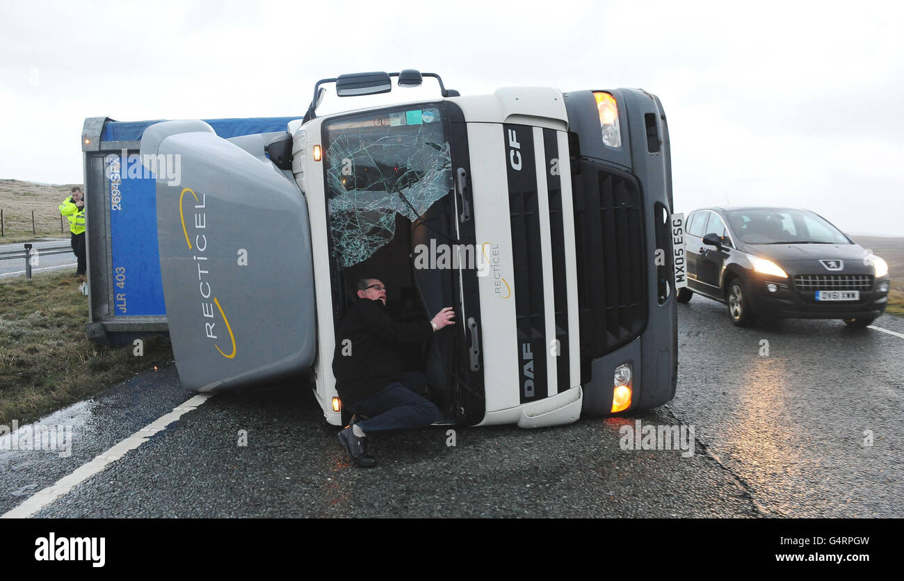 A lorry lies on its side after being blown over in high winds on the ...