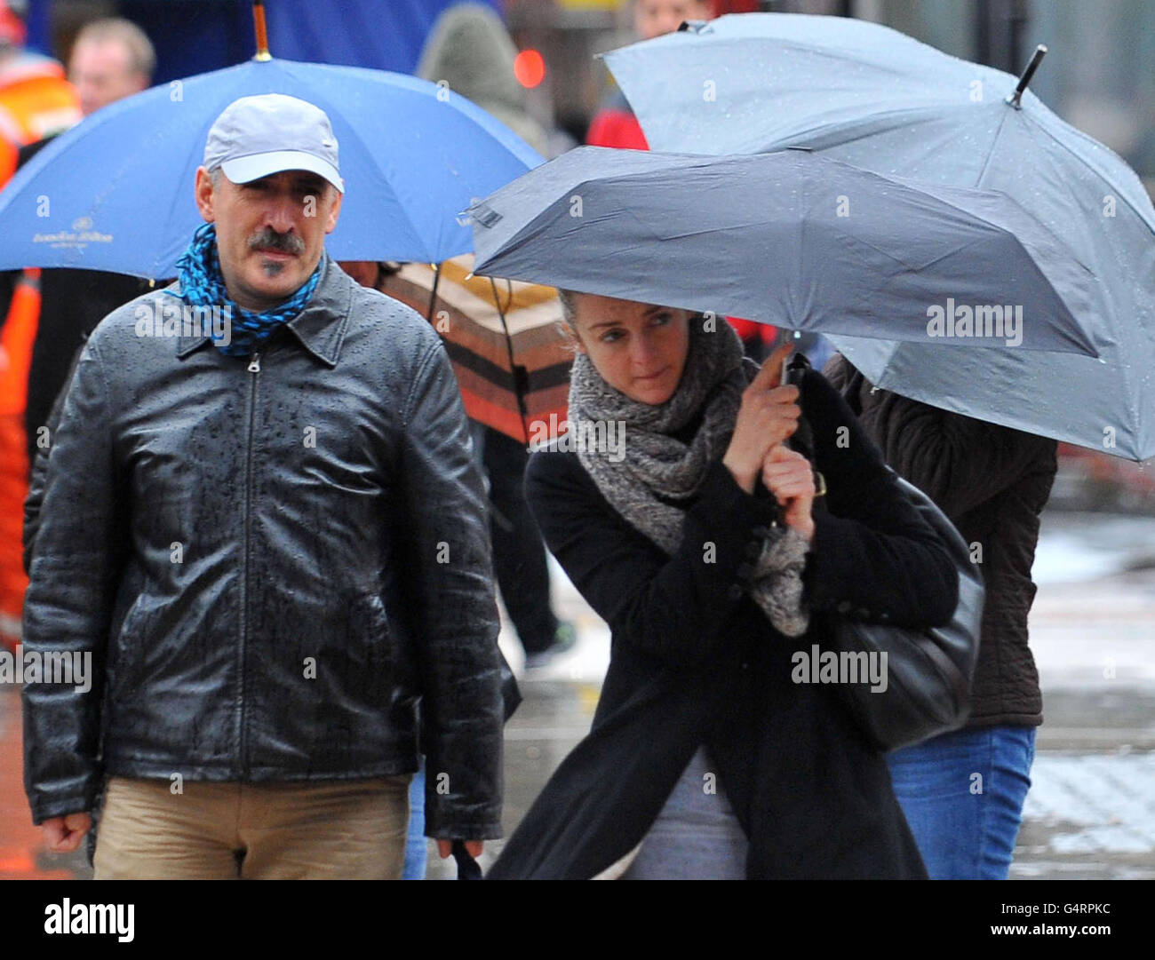 People struggle through the wind and rain while walking out in ...