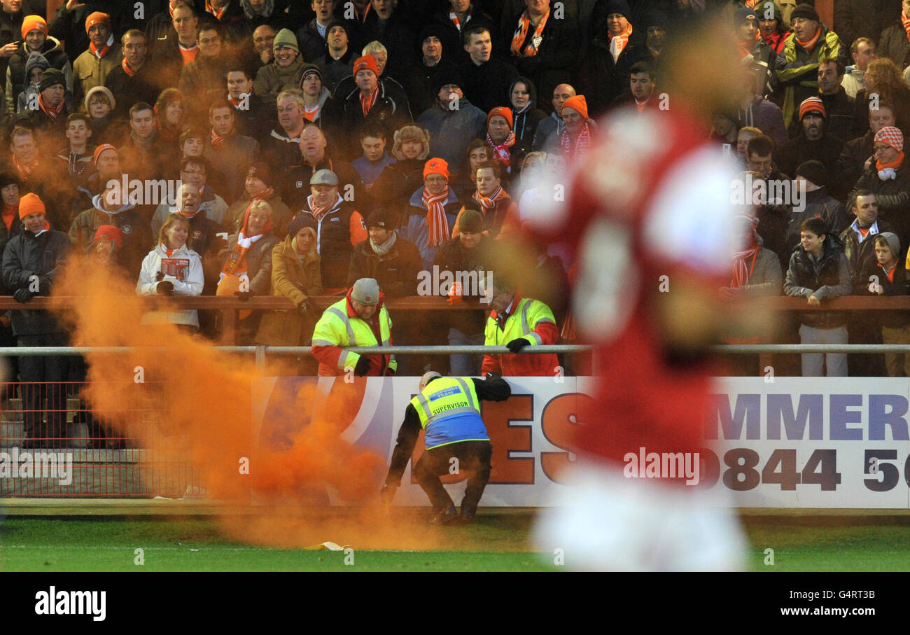 A steward removes a flare thrown by a Blackpool fan during the FA Cup ...