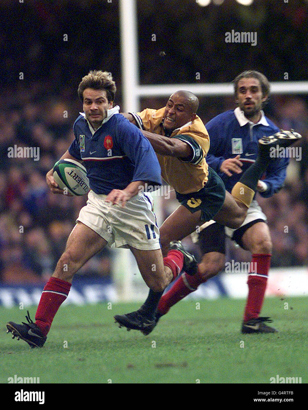 George Gregan of Australia (centre) tackles Christophe Dominici of ...