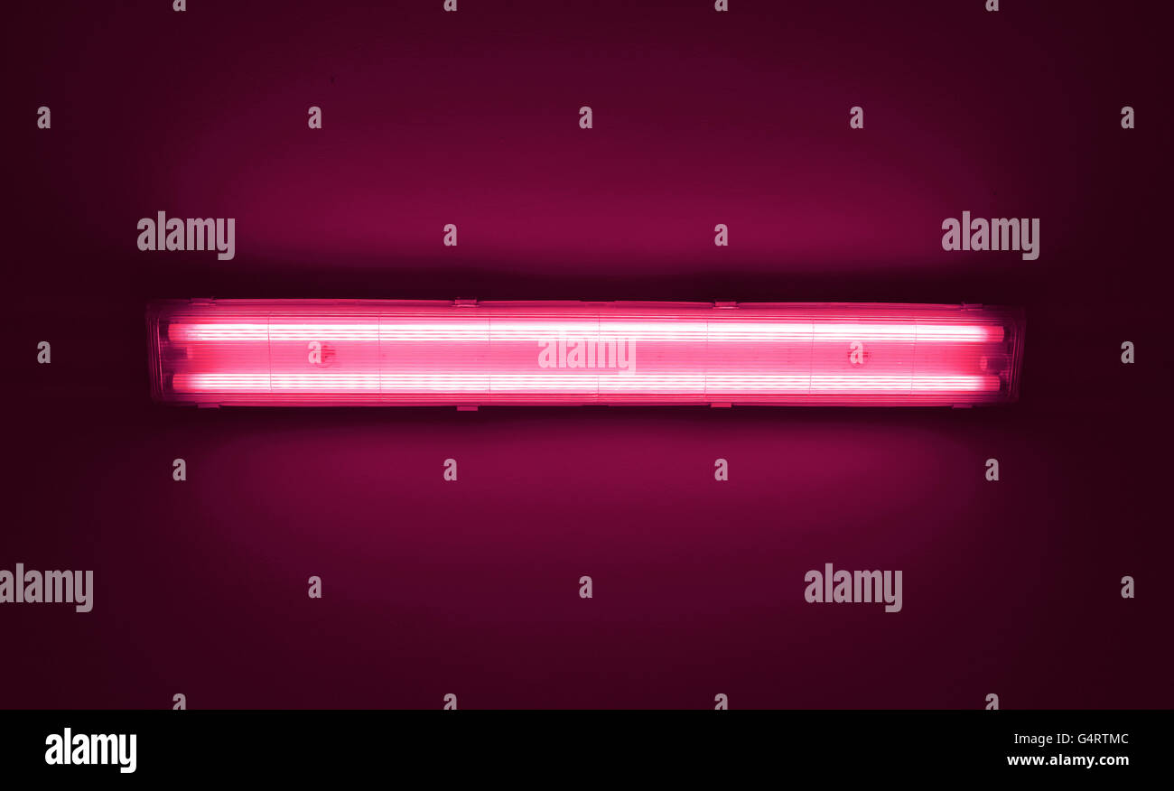 Detail shot of a fluorescent purple light tube on a wall with copyspace ...