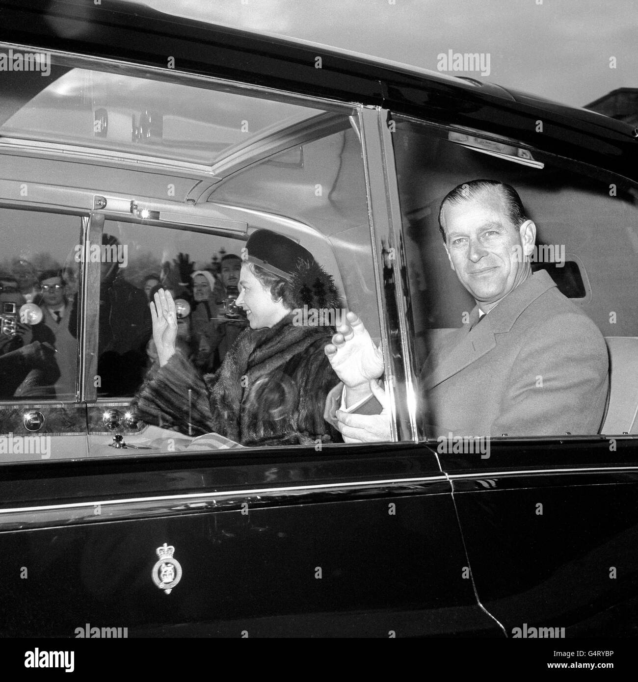 Queen Elizabeth II and the Duke of Edinburgh wave from their car as ...