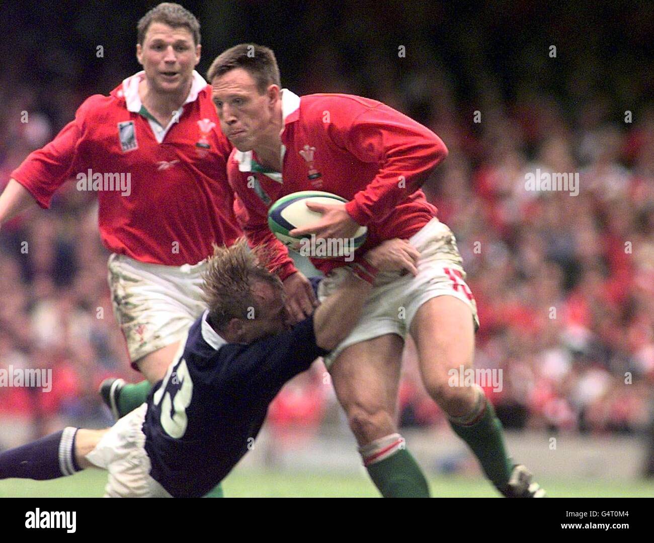 Mark Taylor of Wales breaks through the tackle of Andrew McCormick of ...