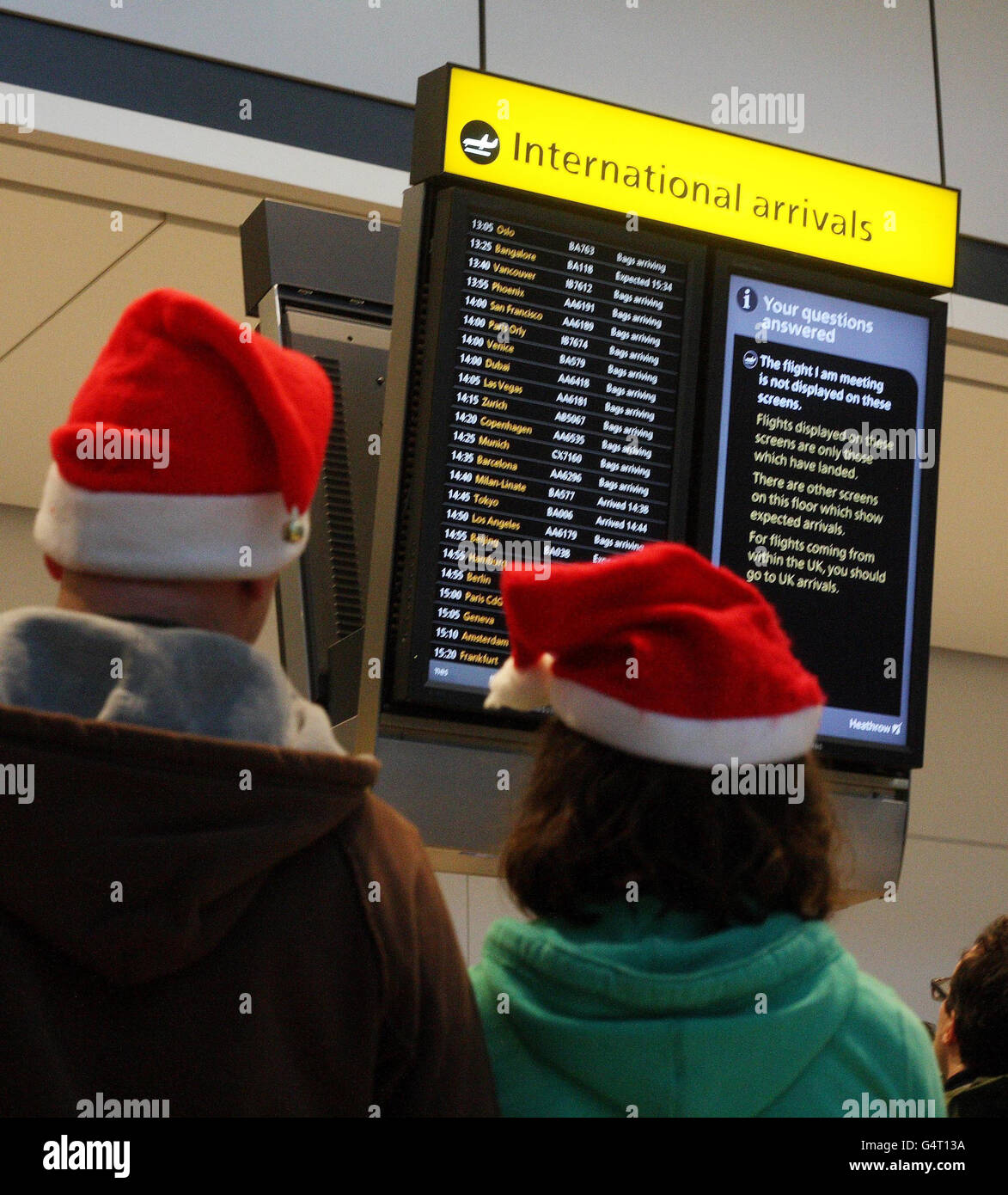 Friends and family members wait for an arriving passenger in Terminal 5 ...