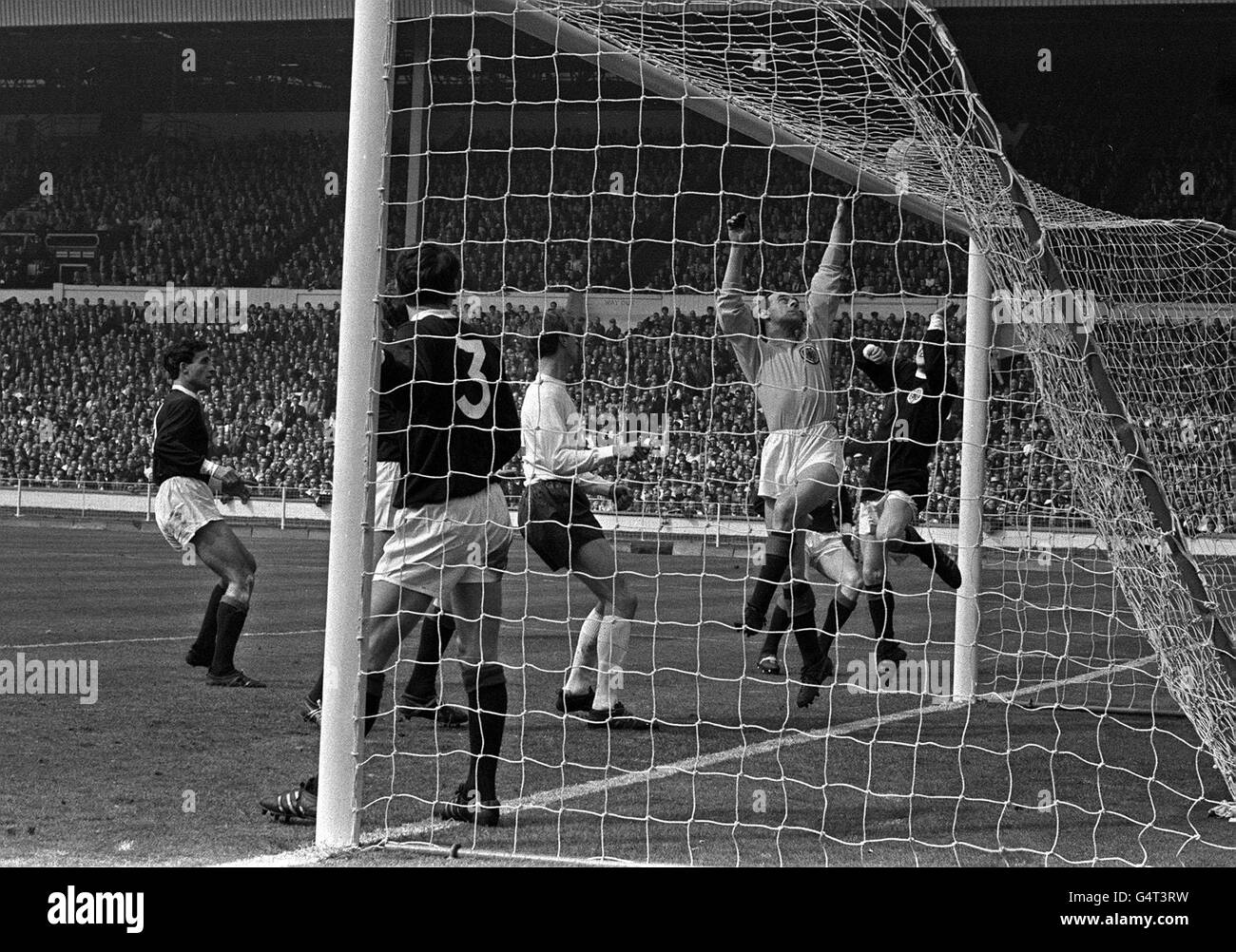 Scotland's newly capped goalkeeper Ronnie Simpson, reaches for the ball ...