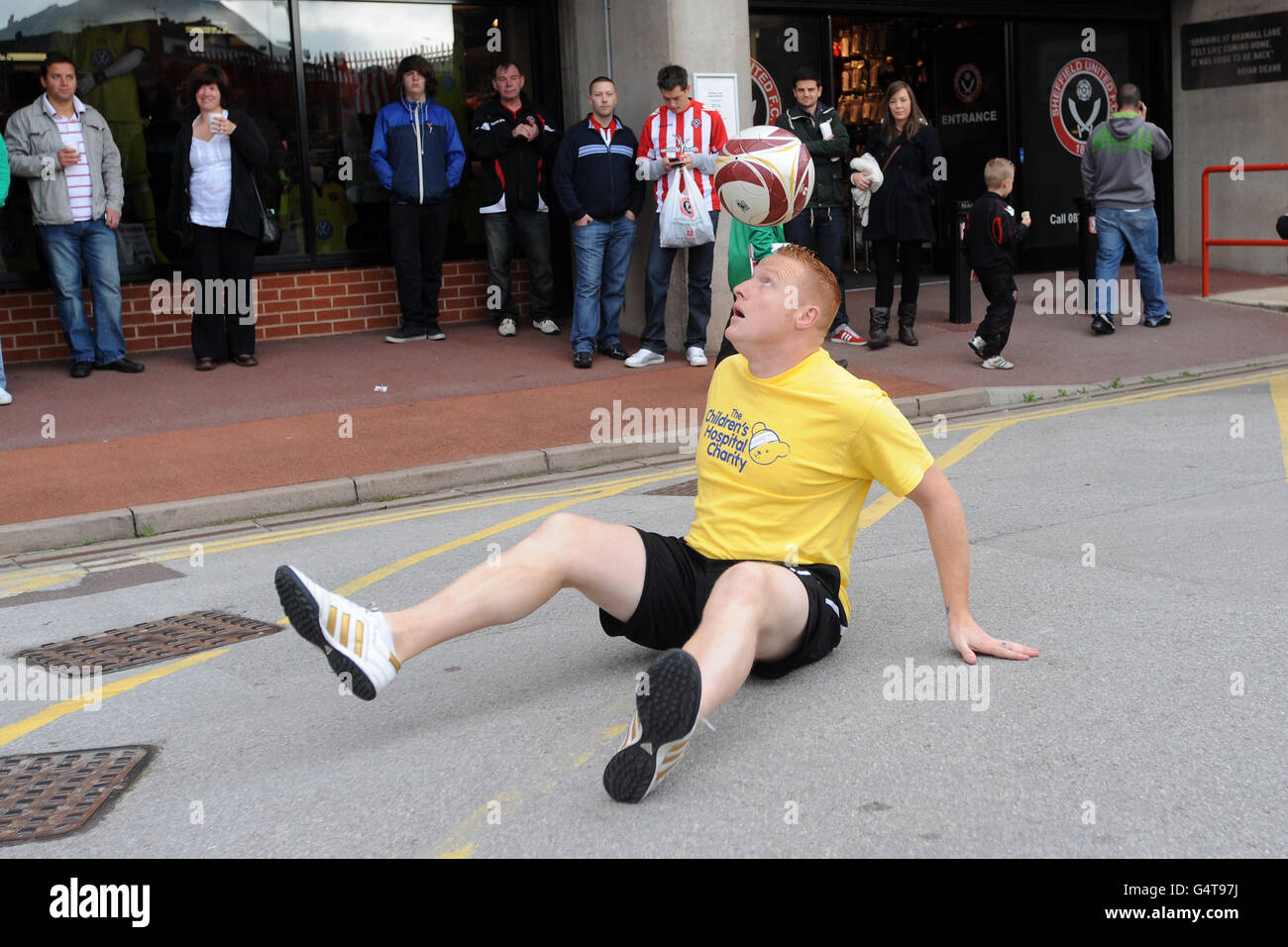 A man entertains the crowd with some ball juggling tricks outside ...