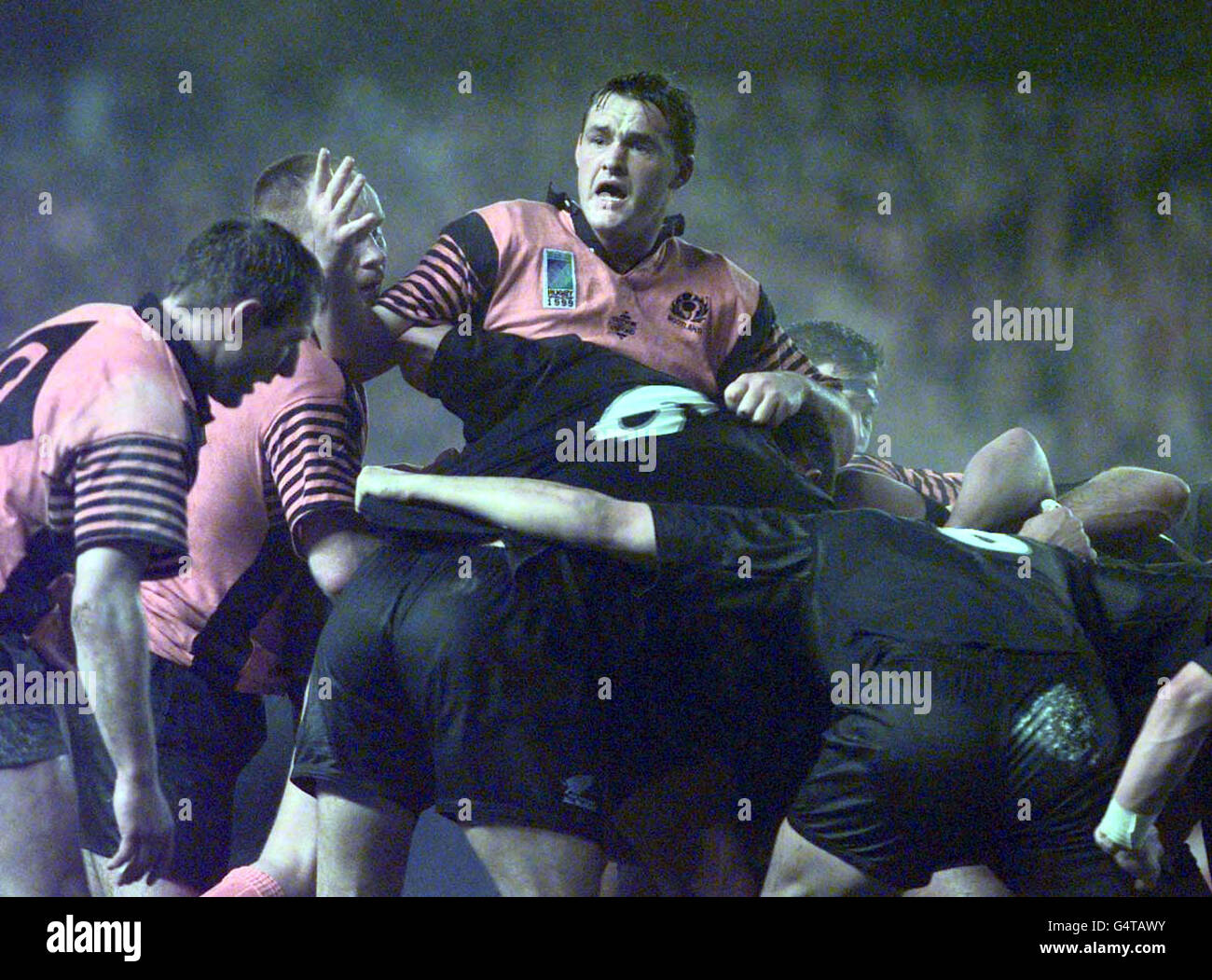 Scotland's Martin Leslie (centre, facing camera) holds off New Zealand ...