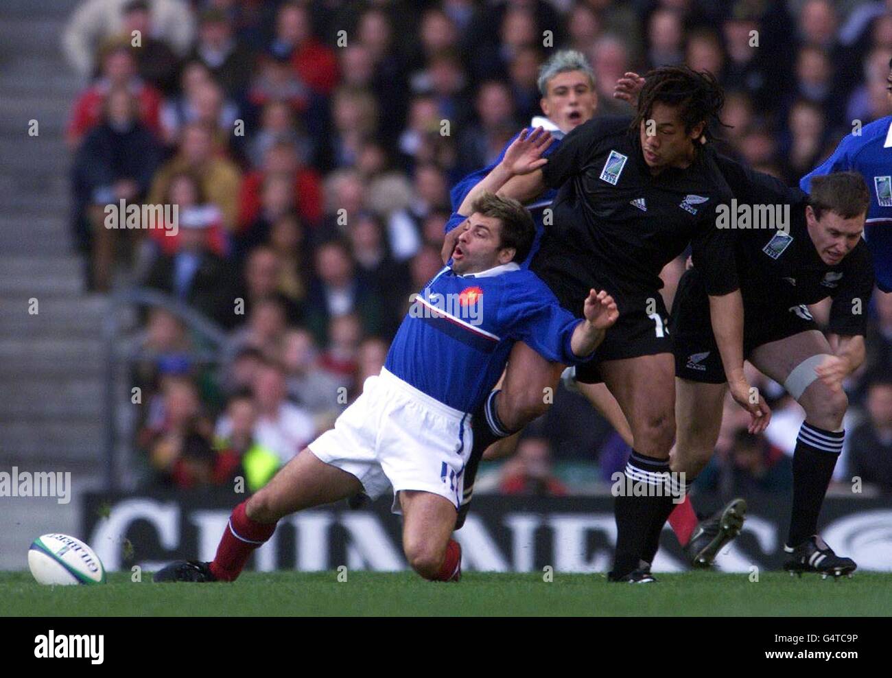 Tana Umaga (R) of the New Zealand All Blacks tackles Christophe ...