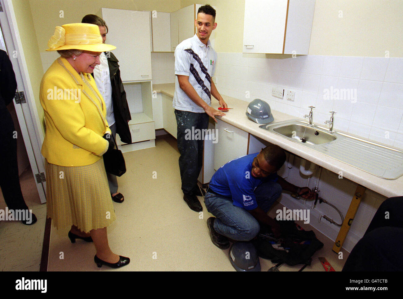 The Queen watches a trainee plumber during a visit to a Prince's Trust ...