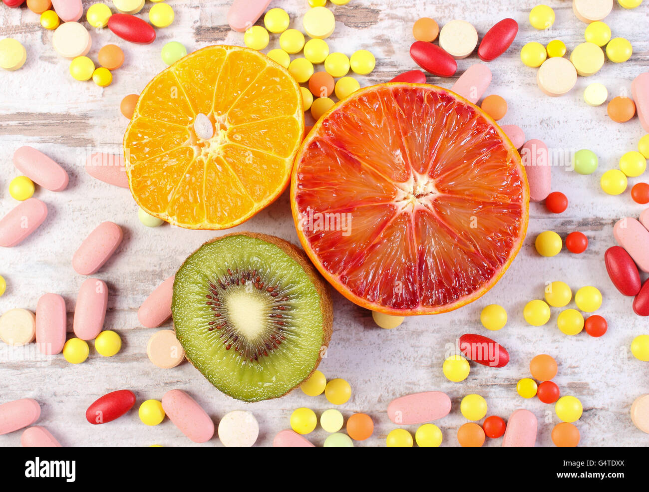 Fresh natural fruits and medical pills, tablets and capsules on rustic ...