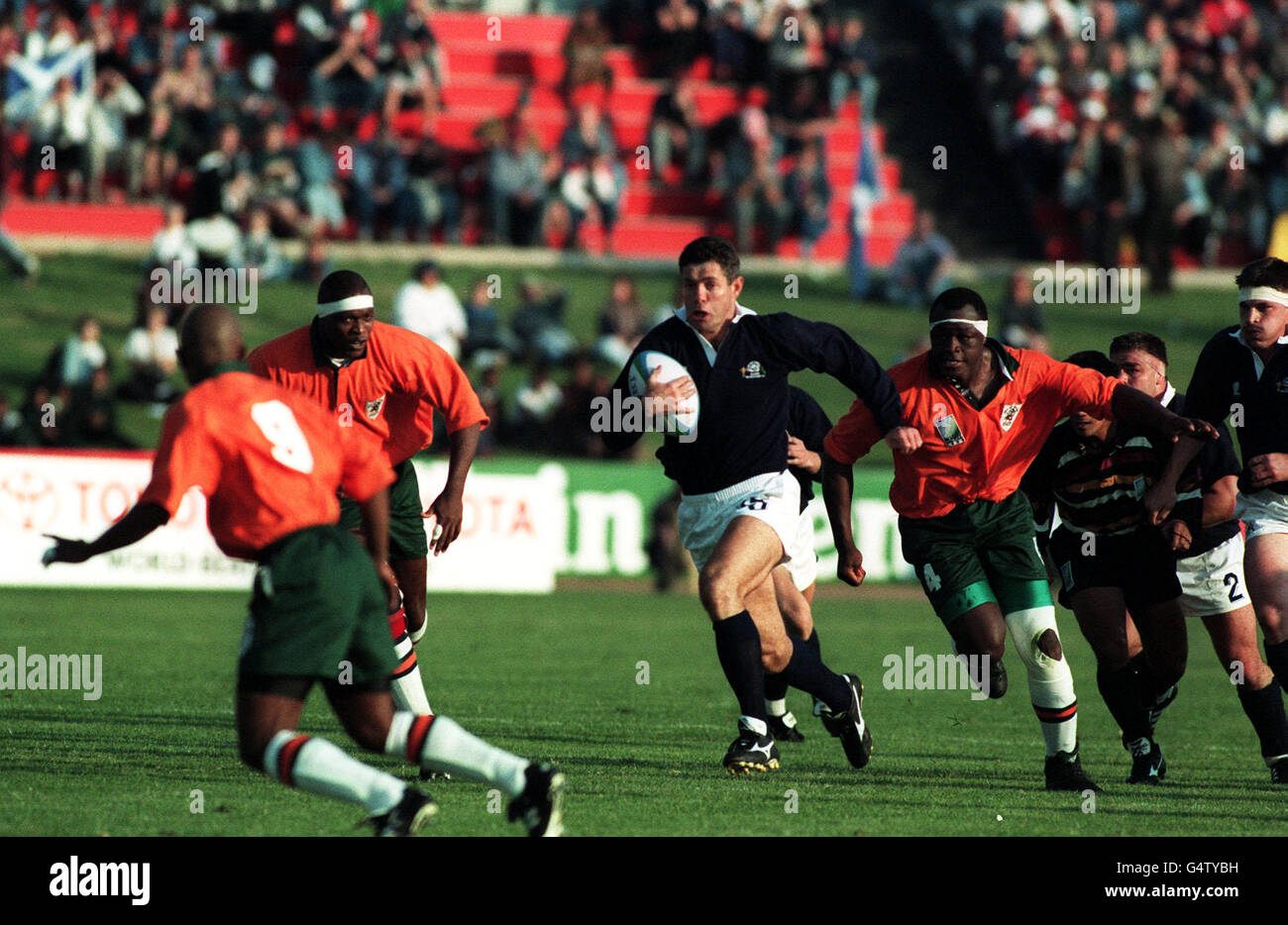 Scotland's Captain Gavin Hastings (C) charges through the Ivory Coast ...