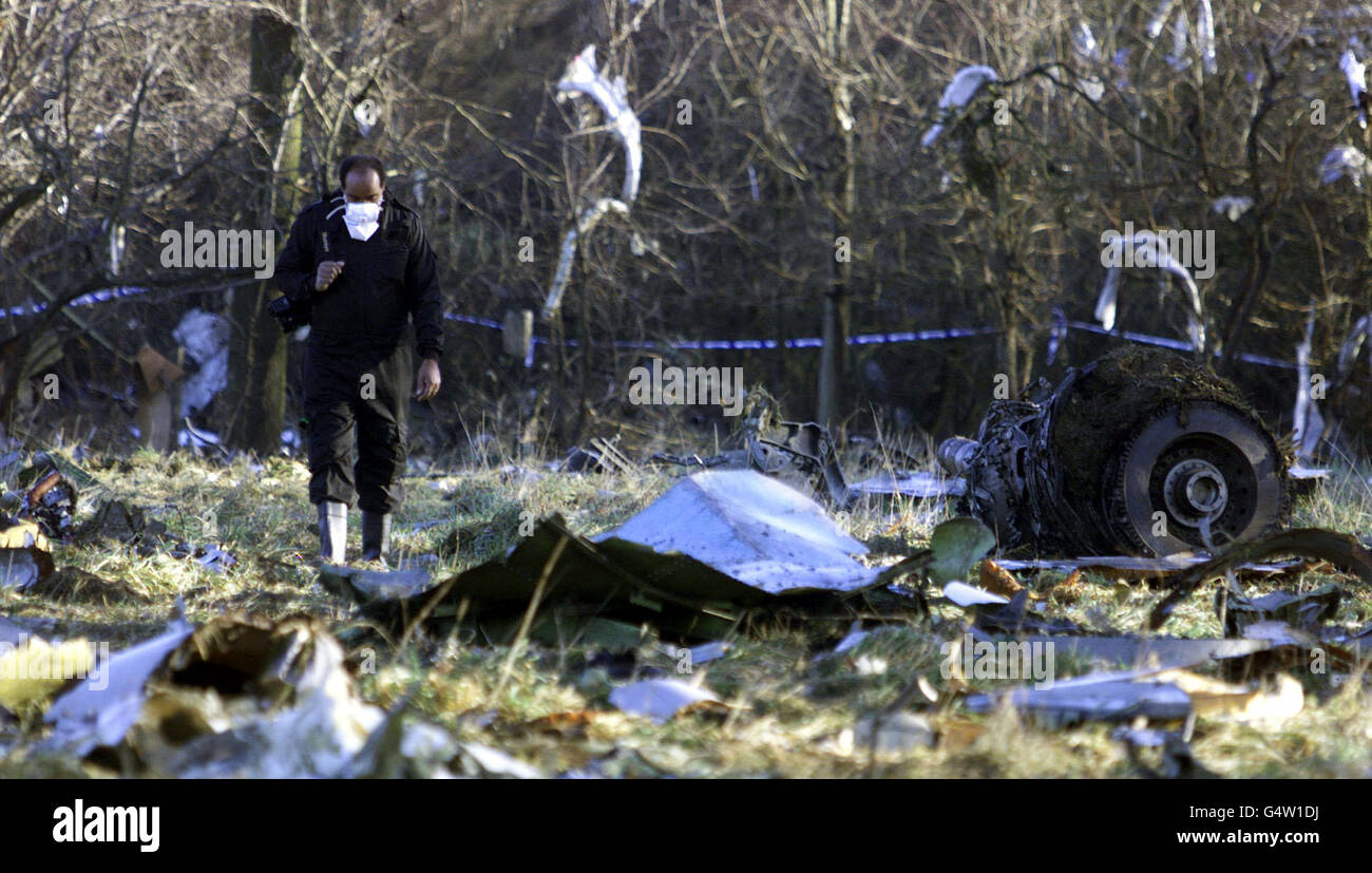 A masked accident investigator examines the site where a Korean 747 ...