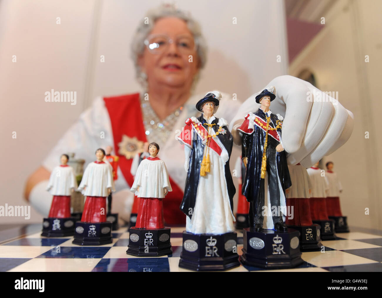 A woman dressed as Queen Elizabeth II, plays with a Studio Anne Carlton ...