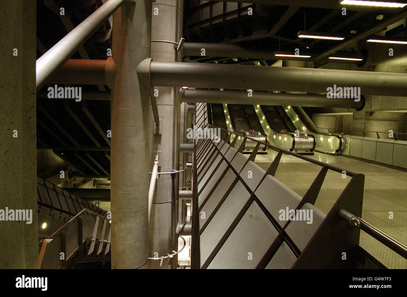 Detail of pipes and a pillar next to a set of escalators and a ...