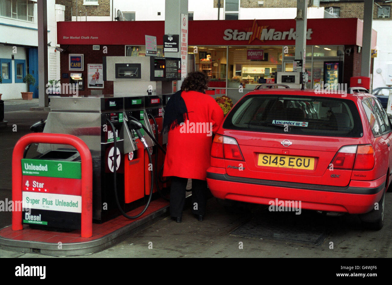 Customer fills her car with petrol at petrol station hi-res stock ...