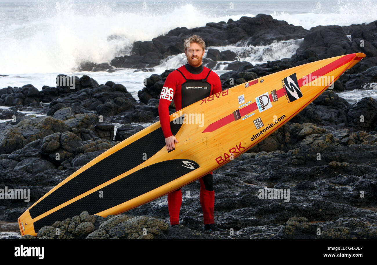 Surfer plans coastal challenge Stock Photo - Alamy