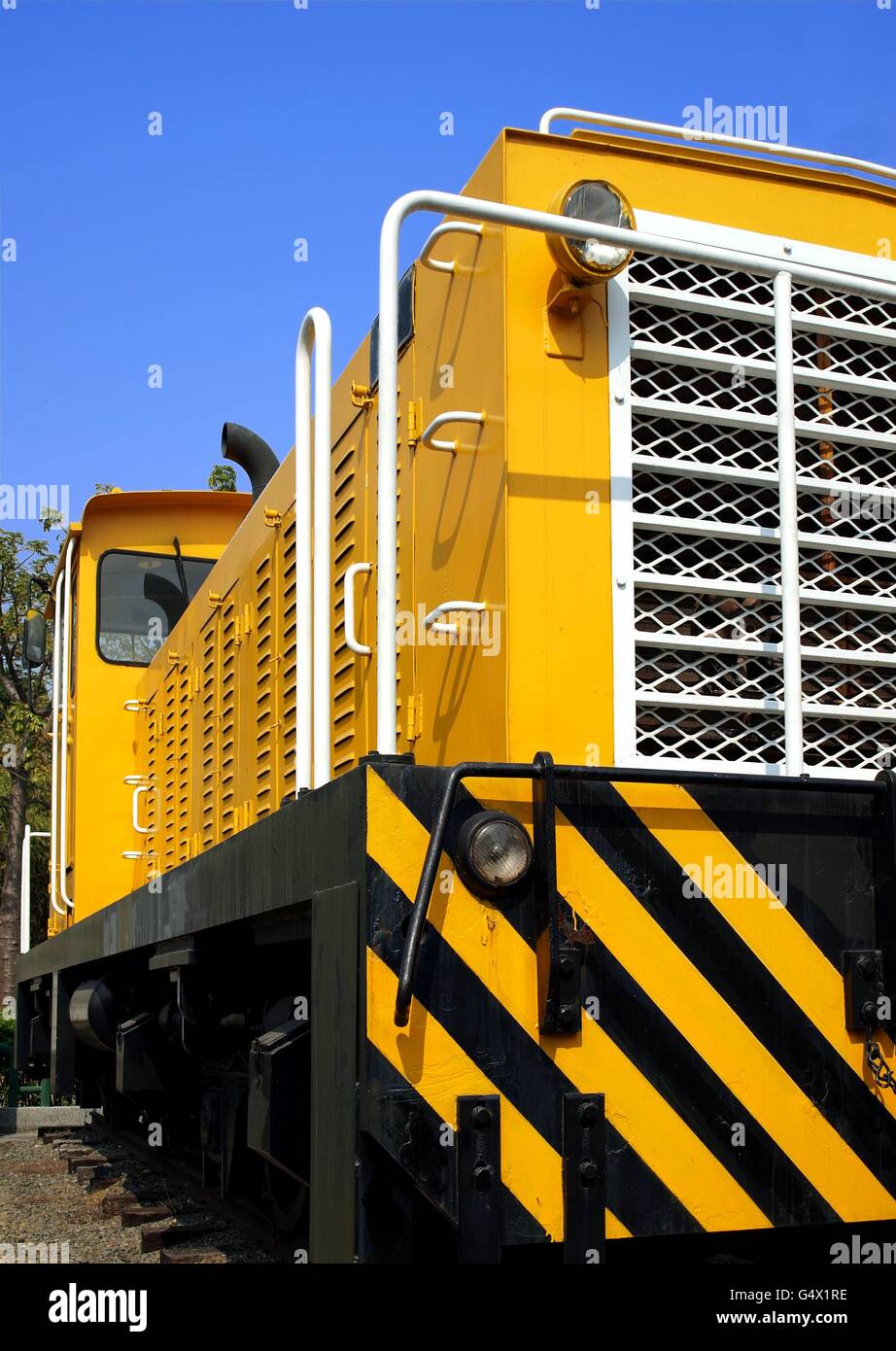 A bright yellow vintage diesel engine designed for narrow railway gauge ...