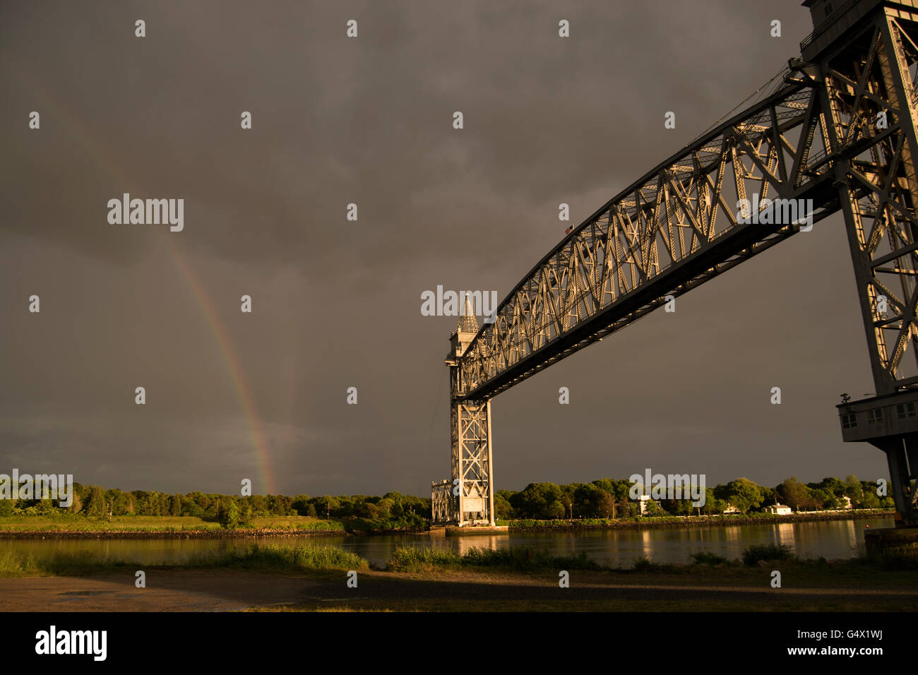 Cape Cod Canal railroad bridge at sunset on cloudy day with rainbow ...