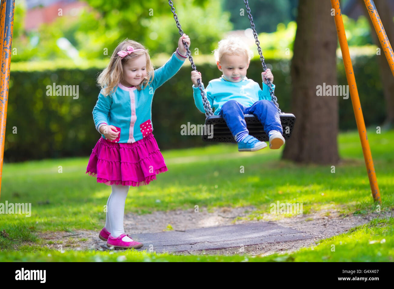 Little boy and girl on a playground. Child playing outdoors in summer ...