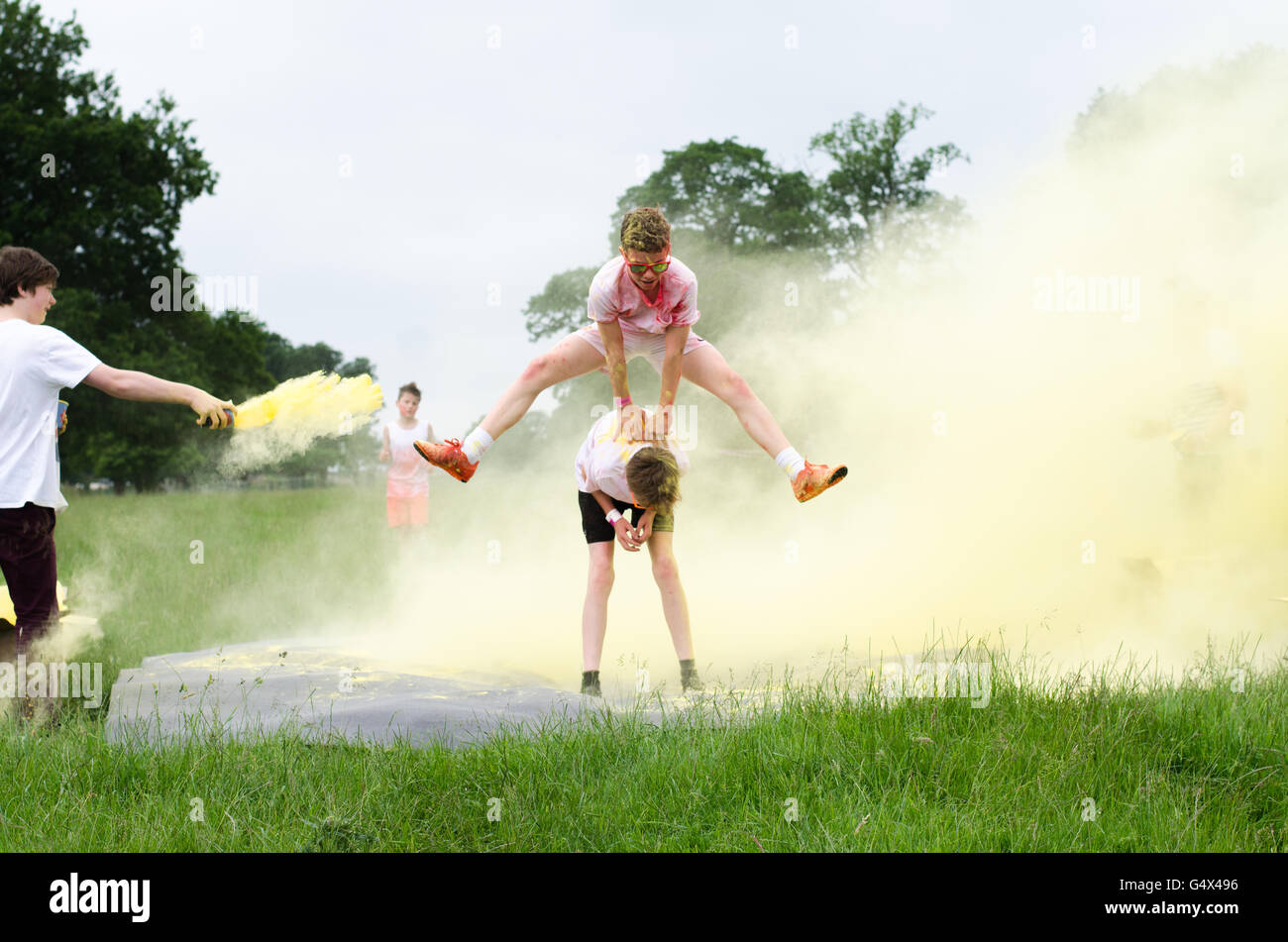 Jumping through coloured paint Stock Photo - Alamy