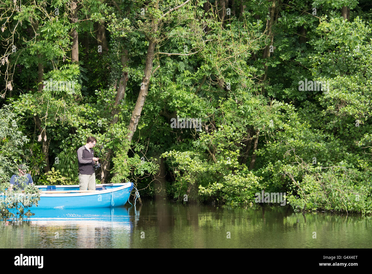 Man fishing from a boat on the Norfolk Broads Stock Photo - Alamy