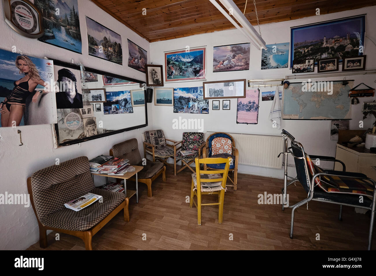 Posters and photographs cover the walls of a barber shop in Anogia, on ...