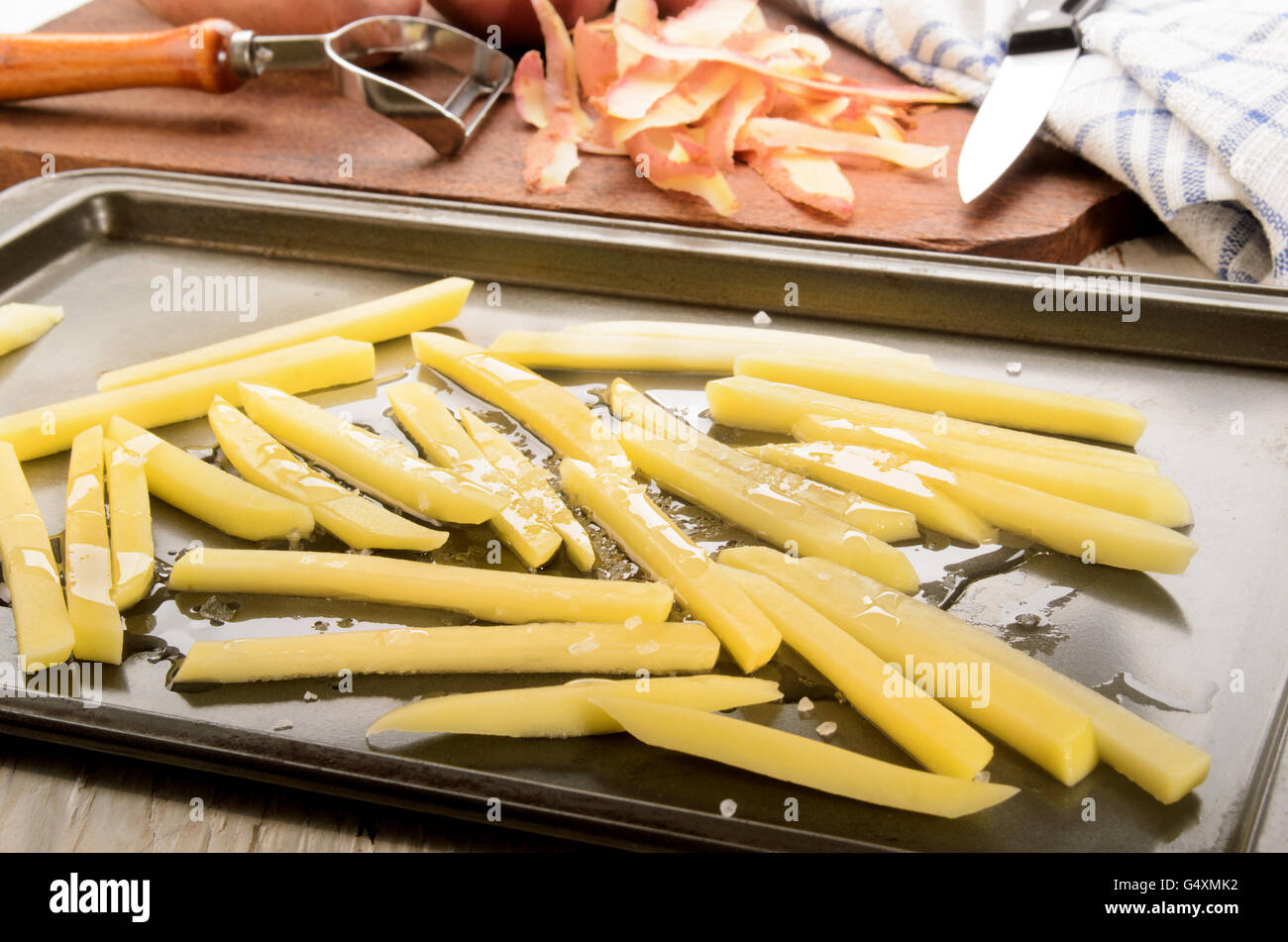 freshly cut french fries with oil and salt on a roasting tin Stock ...