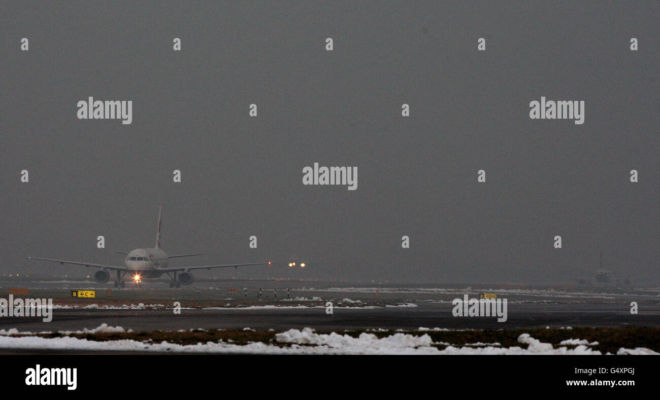A British Airways plane lands in the fog at Heathrow Airport, West ...