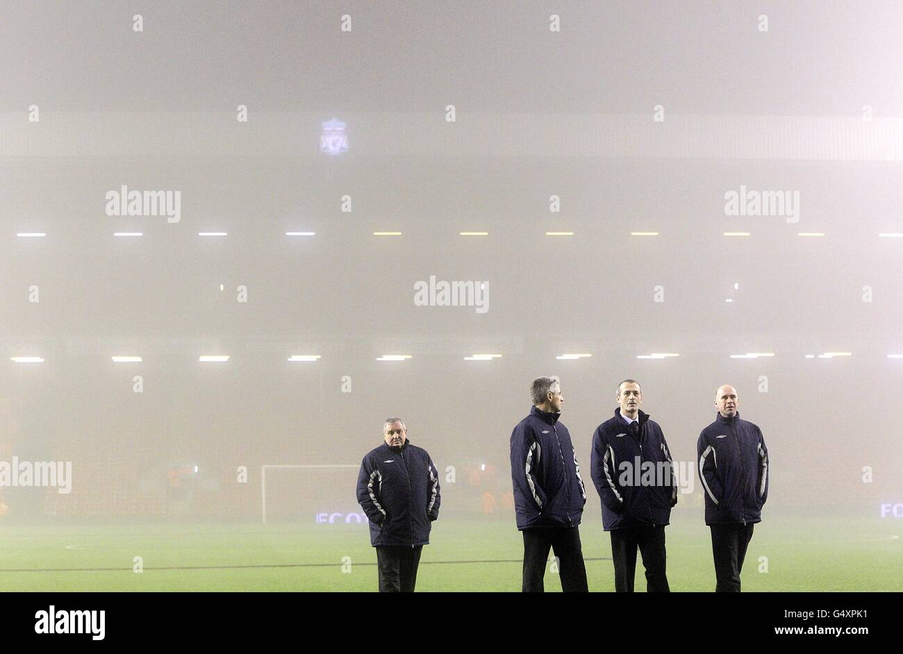 The match officials assess the fog at Anfield ahead of the game Stock ...