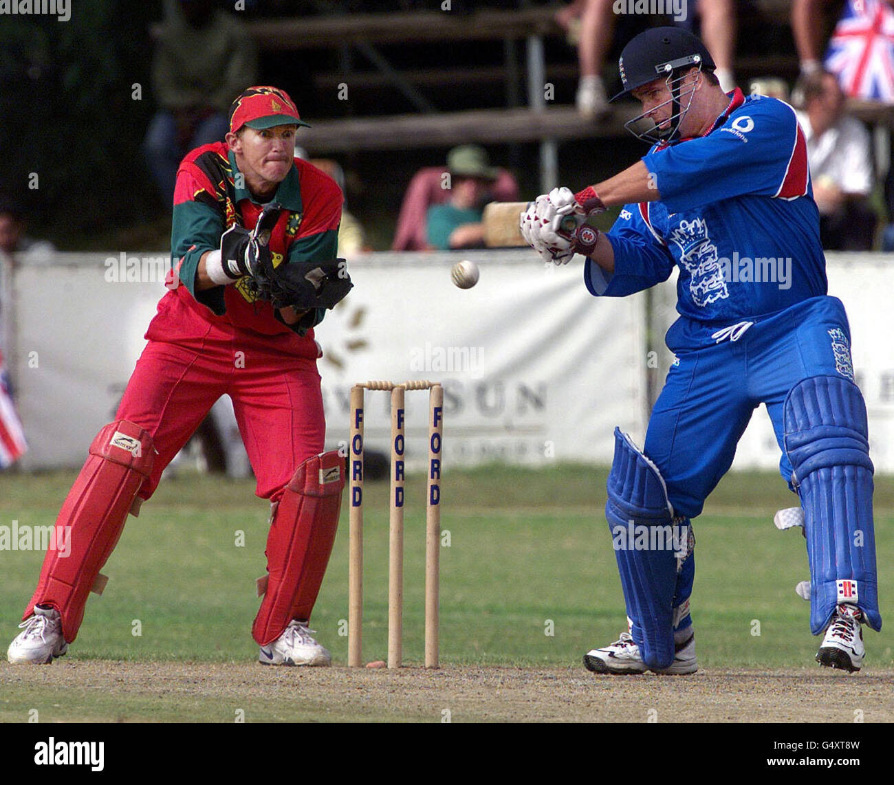 England's Mark Ealham hits the ball for 4 runs, watched by Zimbabwe's ...