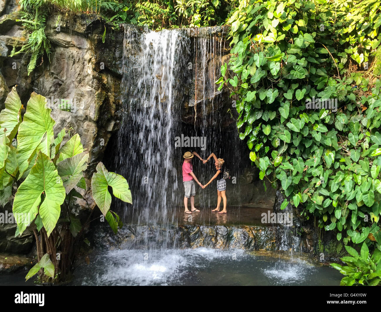 Singapore, Couple forming heart behind a waterfall Stock Photo - Alamy