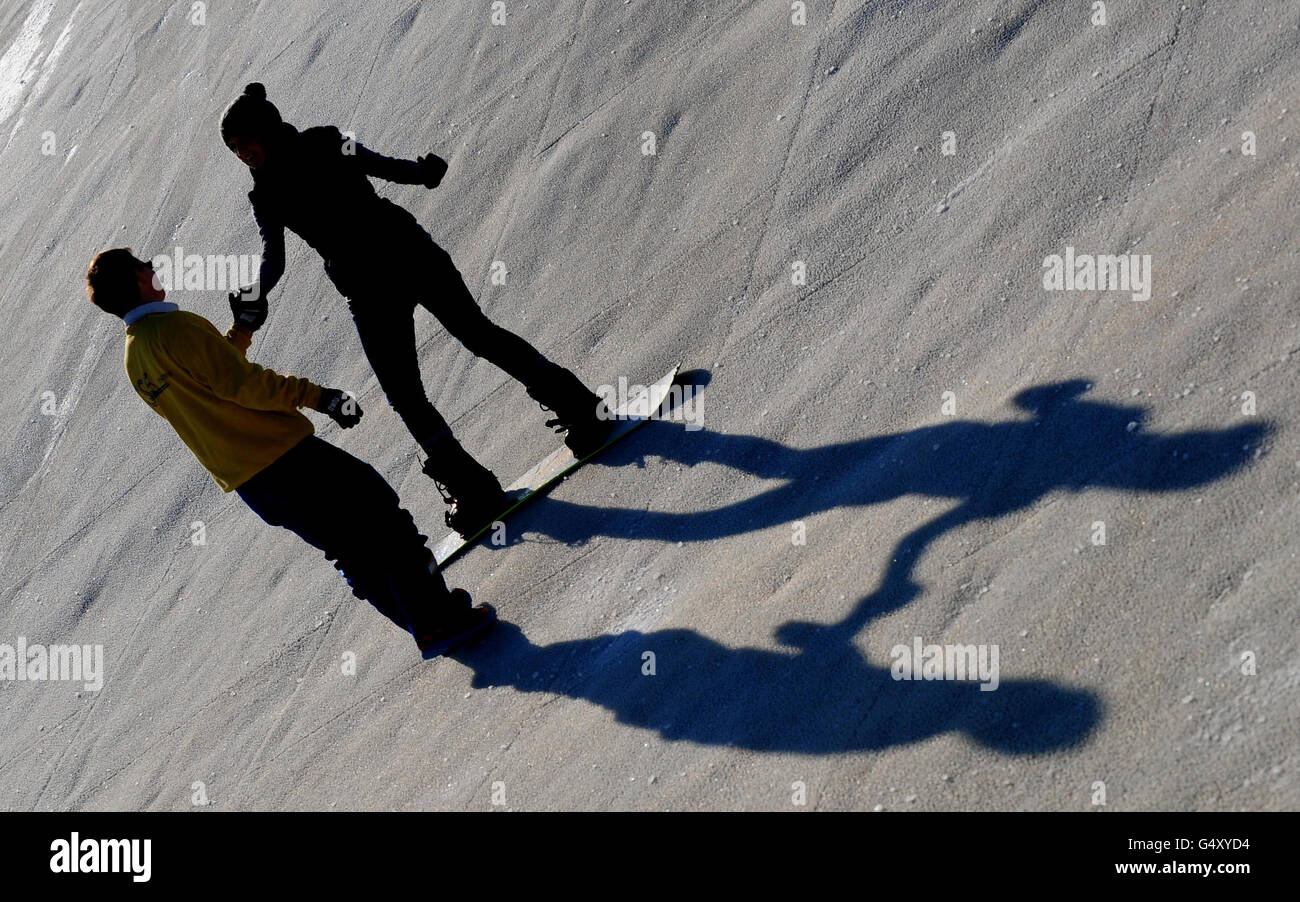 A woman learns to snowboard on the dry ski slope at Swadlincote Ski and ...
