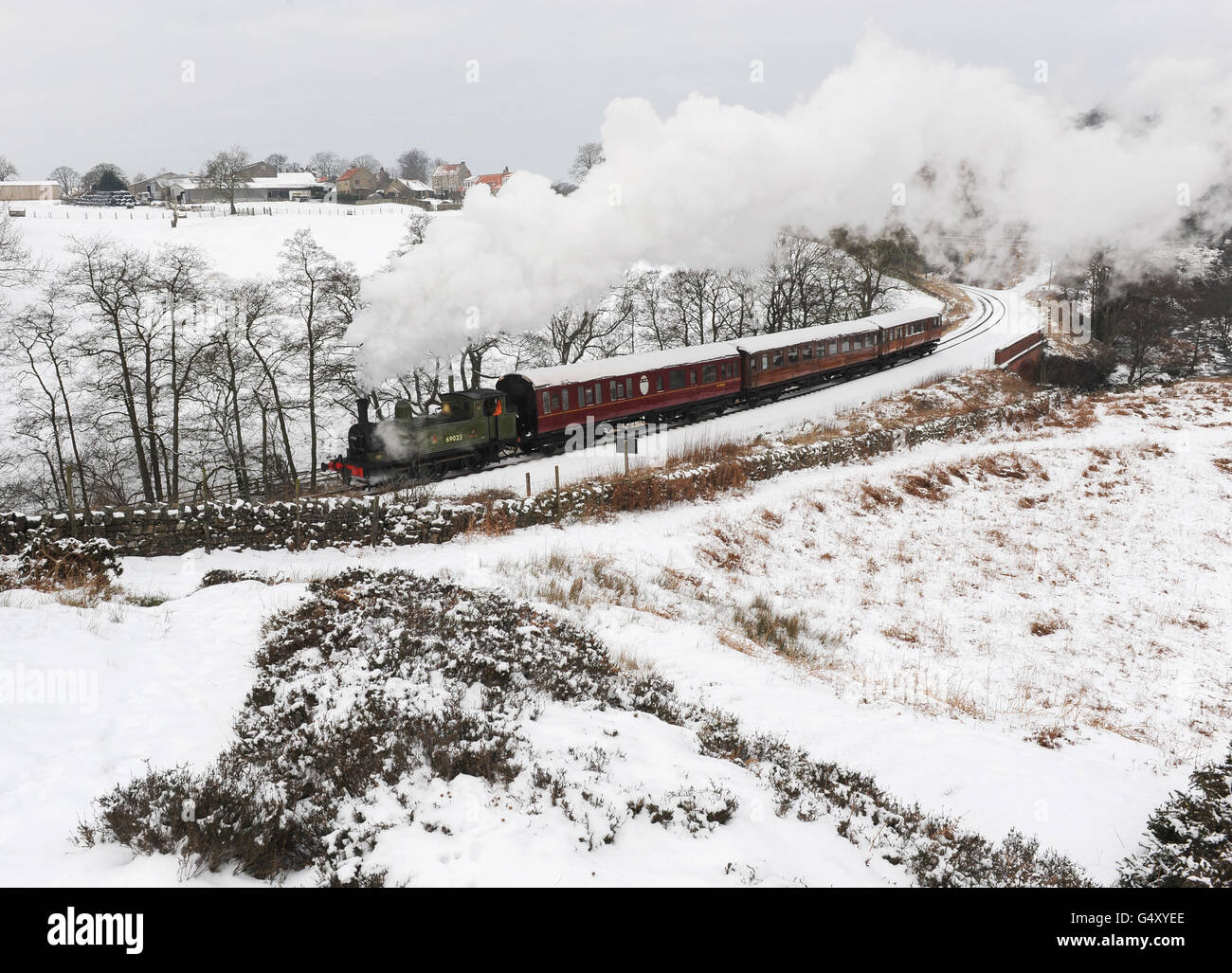 The steam engine 'Joem' pulls carriages along the snow covered North ...