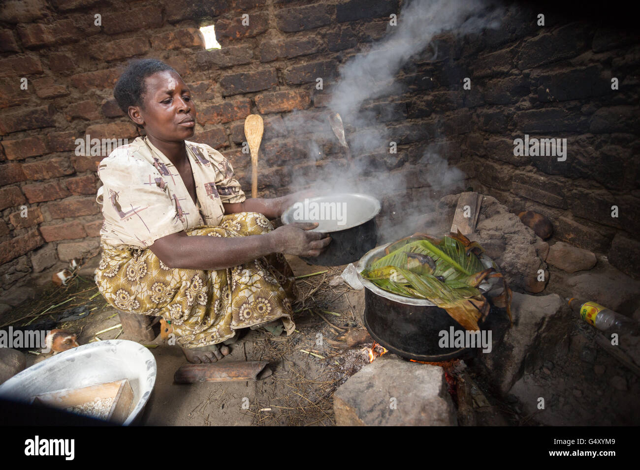 A woman cooks food over an open fire in Kasese District, Uganda, East ...