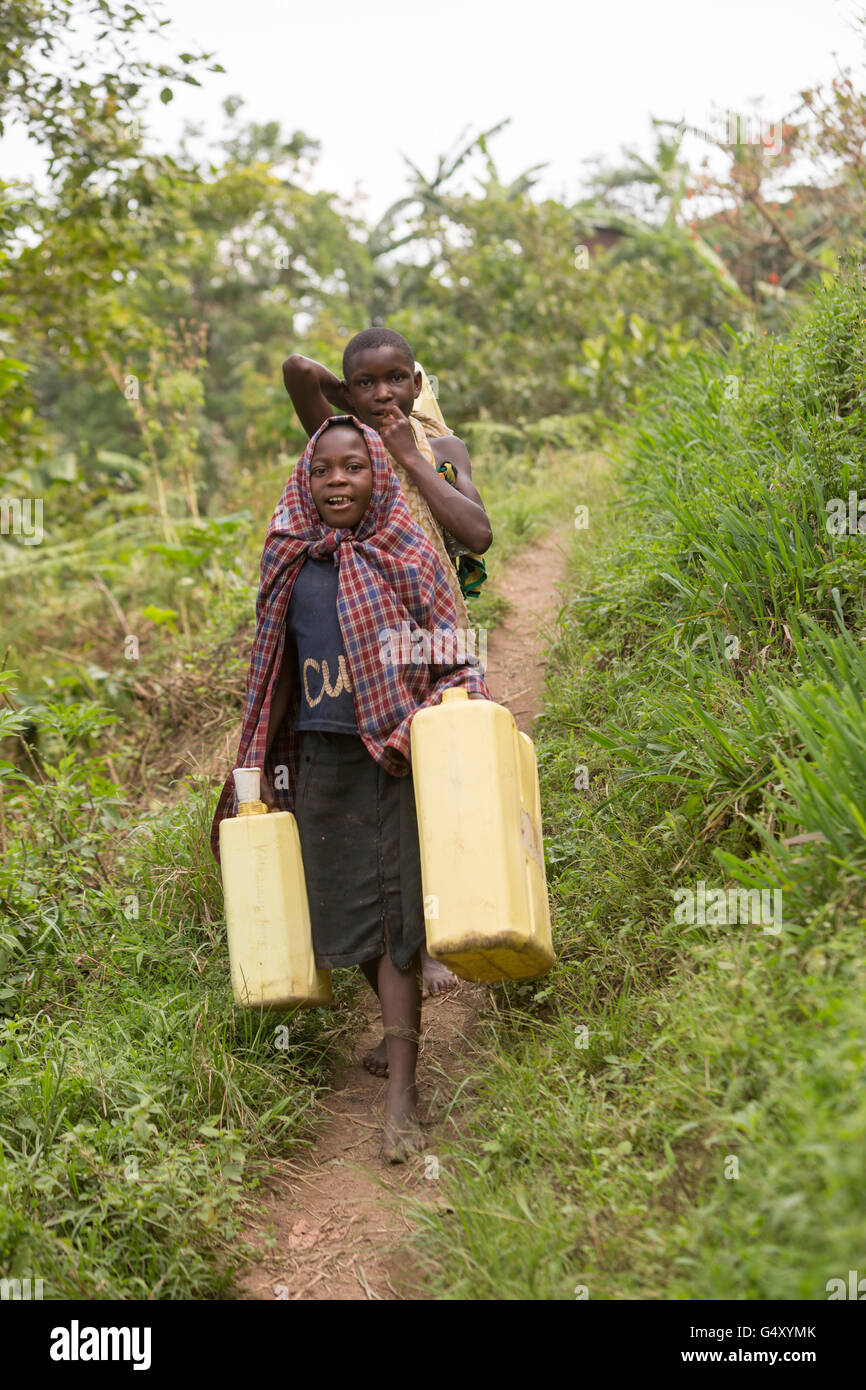 Children carry water cans down a village path in Kasese District ...