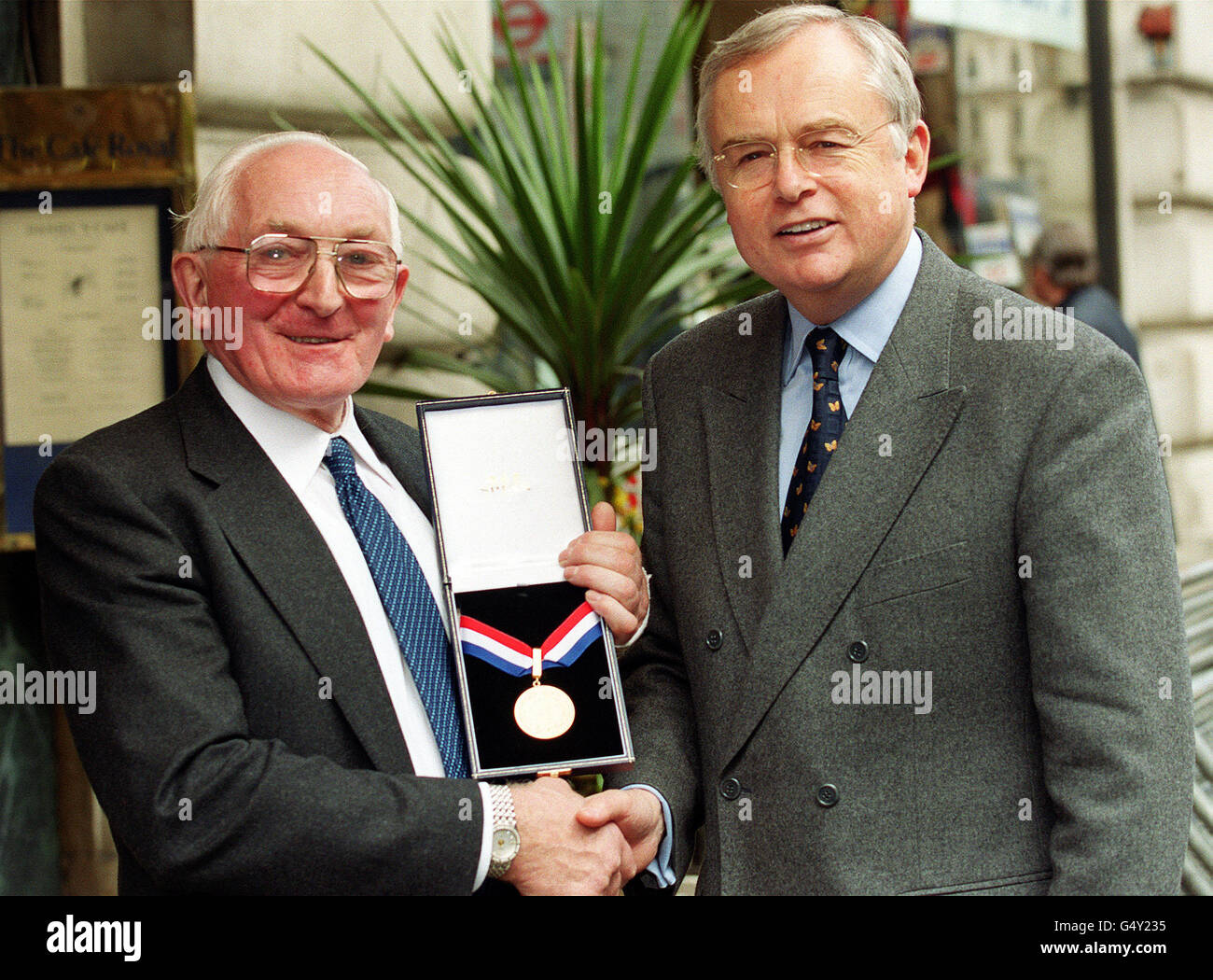 Smiling shaking hands celebrity medal newsreader hi-res stock ...