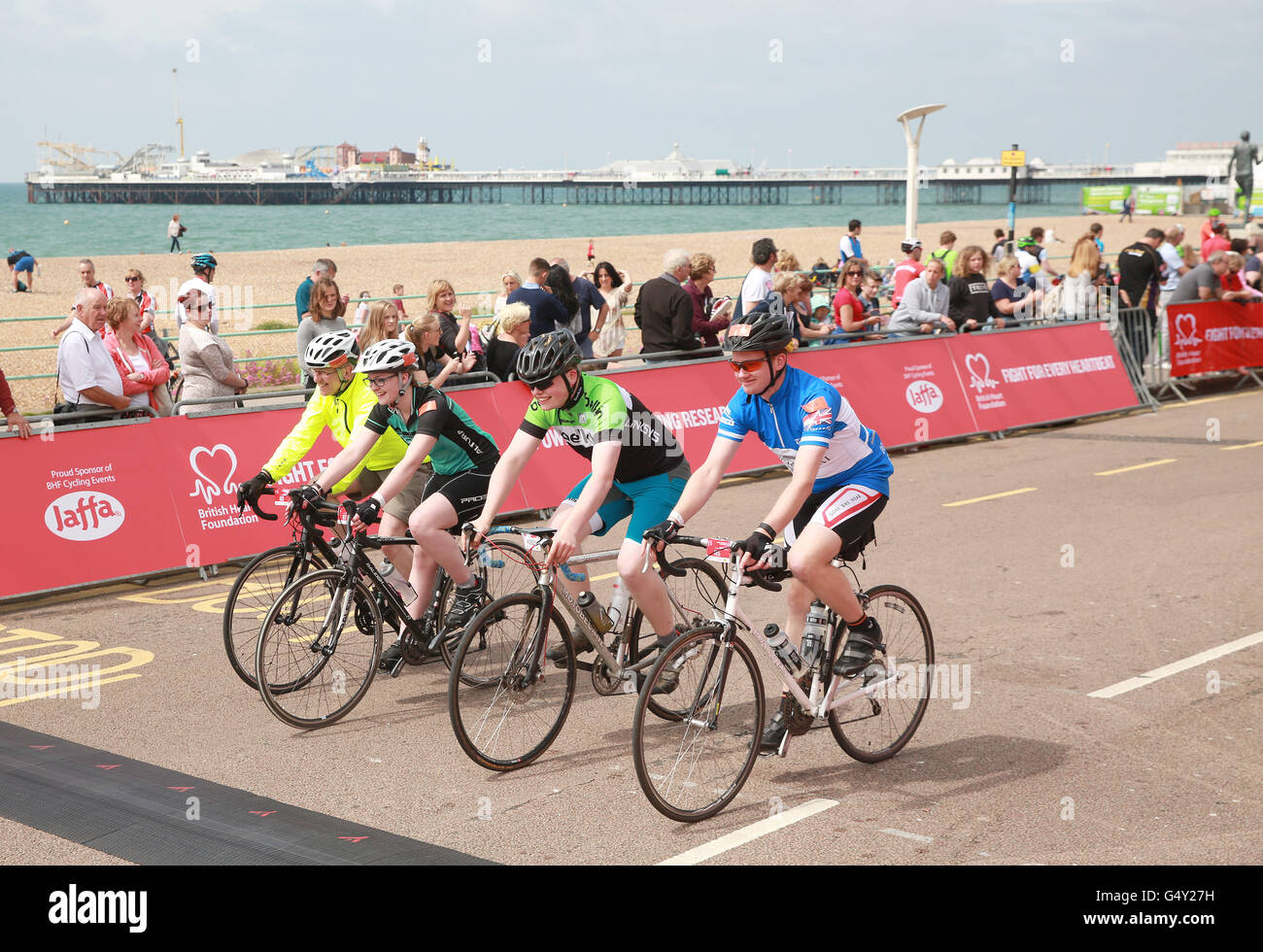 EDITORIAL USE ONLY Cyclists cross the finishing line in Brighton after ...