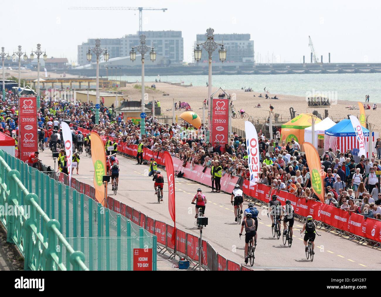 EDITORIAL USE ONLY Cyclists cross the finishing line in Brighton after ...
