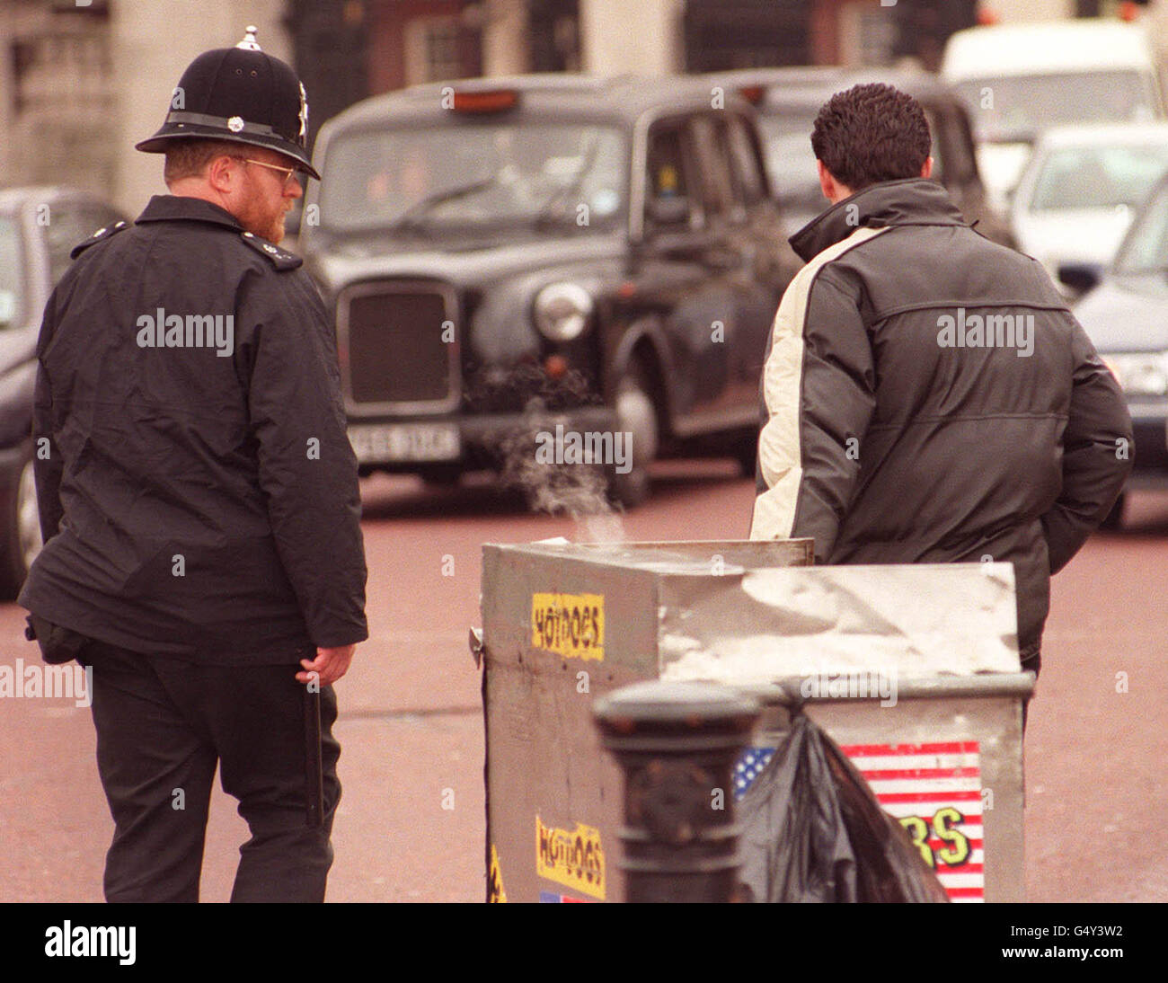 A hot dog seller is escorted away from Buckingham Palace, where he had ...