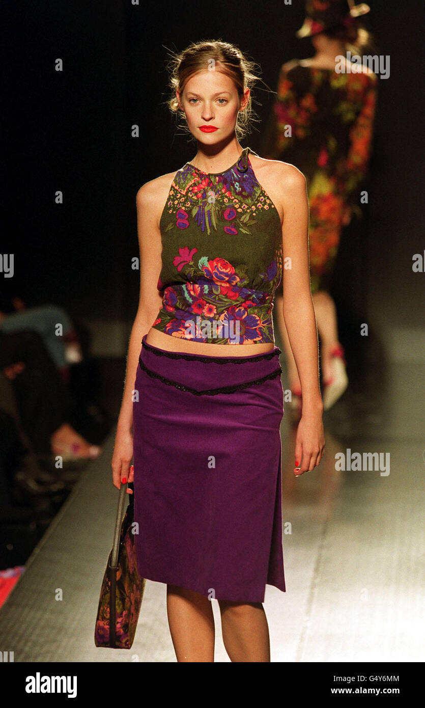 A model wears a green patterned top, with matching bag, and a purple ...