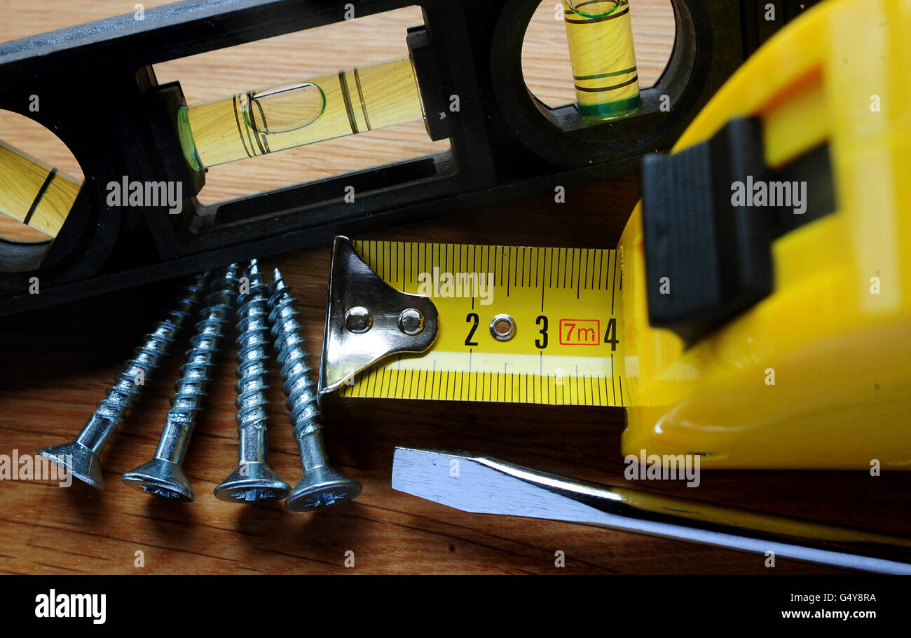 General view of screws, a tape measure, a screwdriver, and a spirit ...