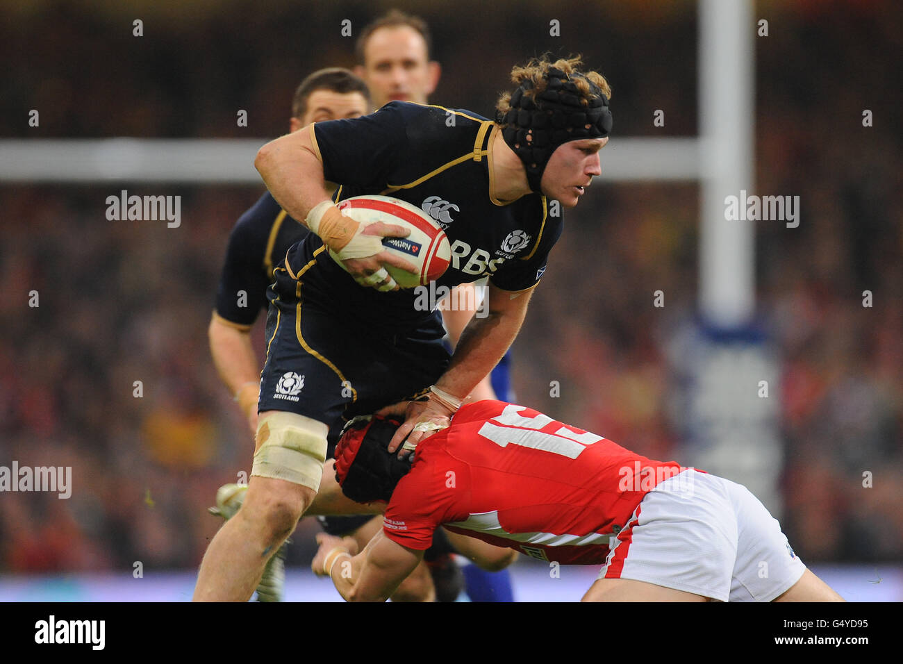 Wales' Leigh Halfpenny tackles Scotland's Ross Rennie Stock Photo - Alamy